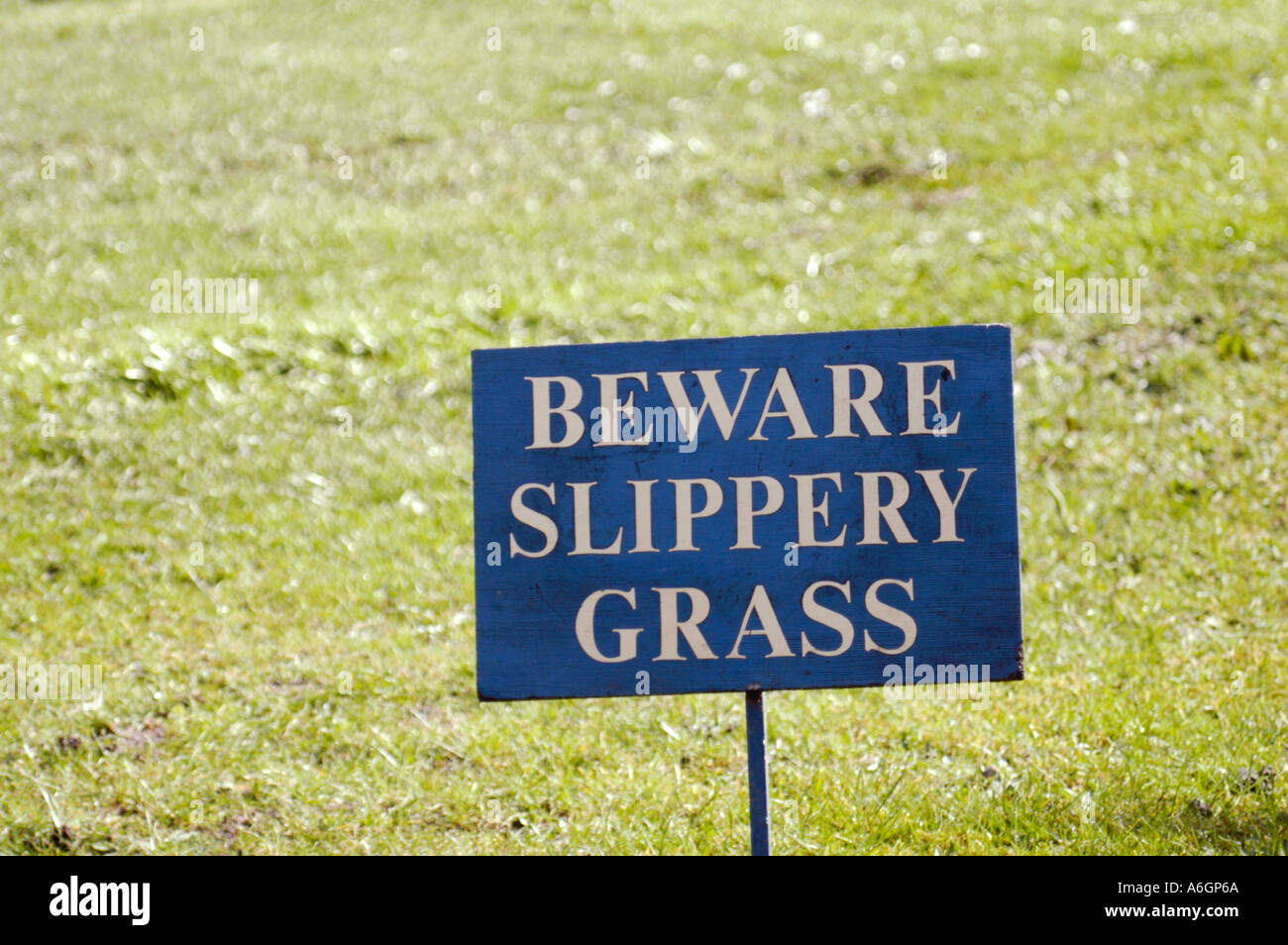 Slippery grass warning sign Stock Photo - Alamy