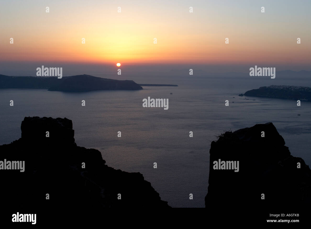 Sunset with sun setting into the sea Stock Photo - Alamy