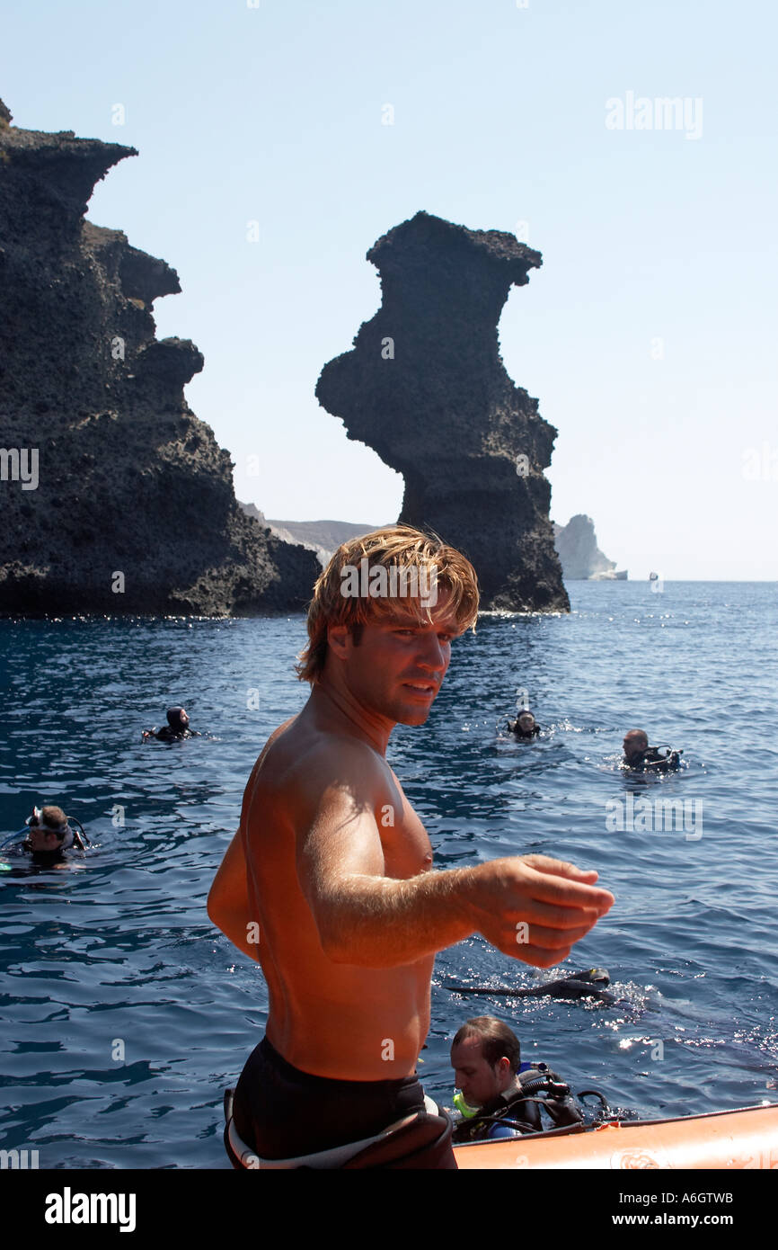 Diving instructor and divers with dramatic cliff rock formations on ...