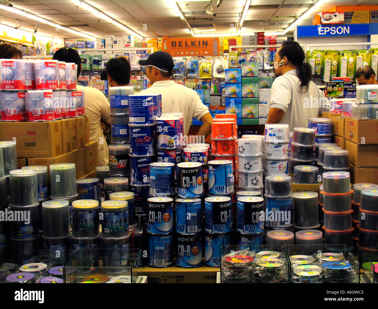 Computer enthusiasts examine equipment behind piles of computer discs ...