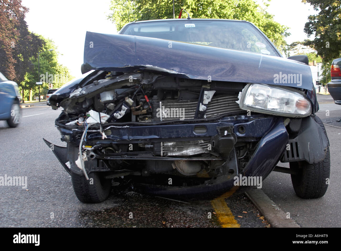 Smashed up damaged car from road traffic accident parked on the side of ...