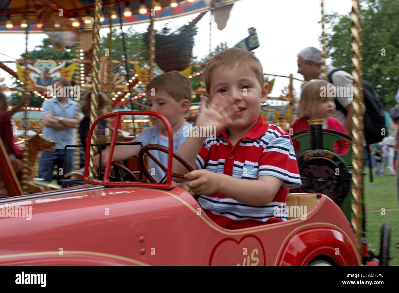Young boy child on a model car fairground ride at Carter s Steam Fair ...