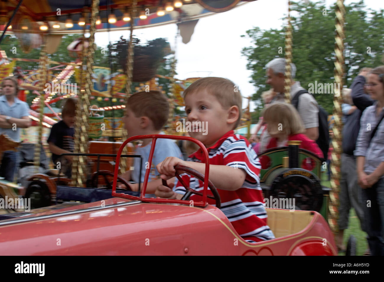 Young boy child on a model car fairground ride at Carter s Steam Fair ...