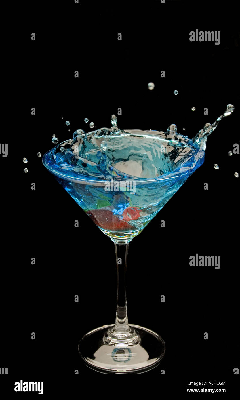 Blue cocktail drink splashing with a strawberry fruit in the glass ...