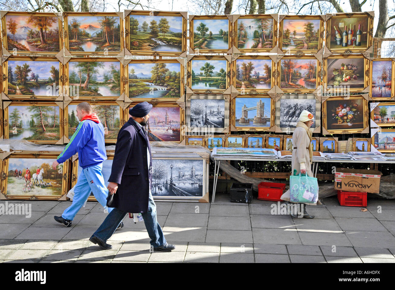 people walk past a selection of paintings for sale on Piccadilly ...