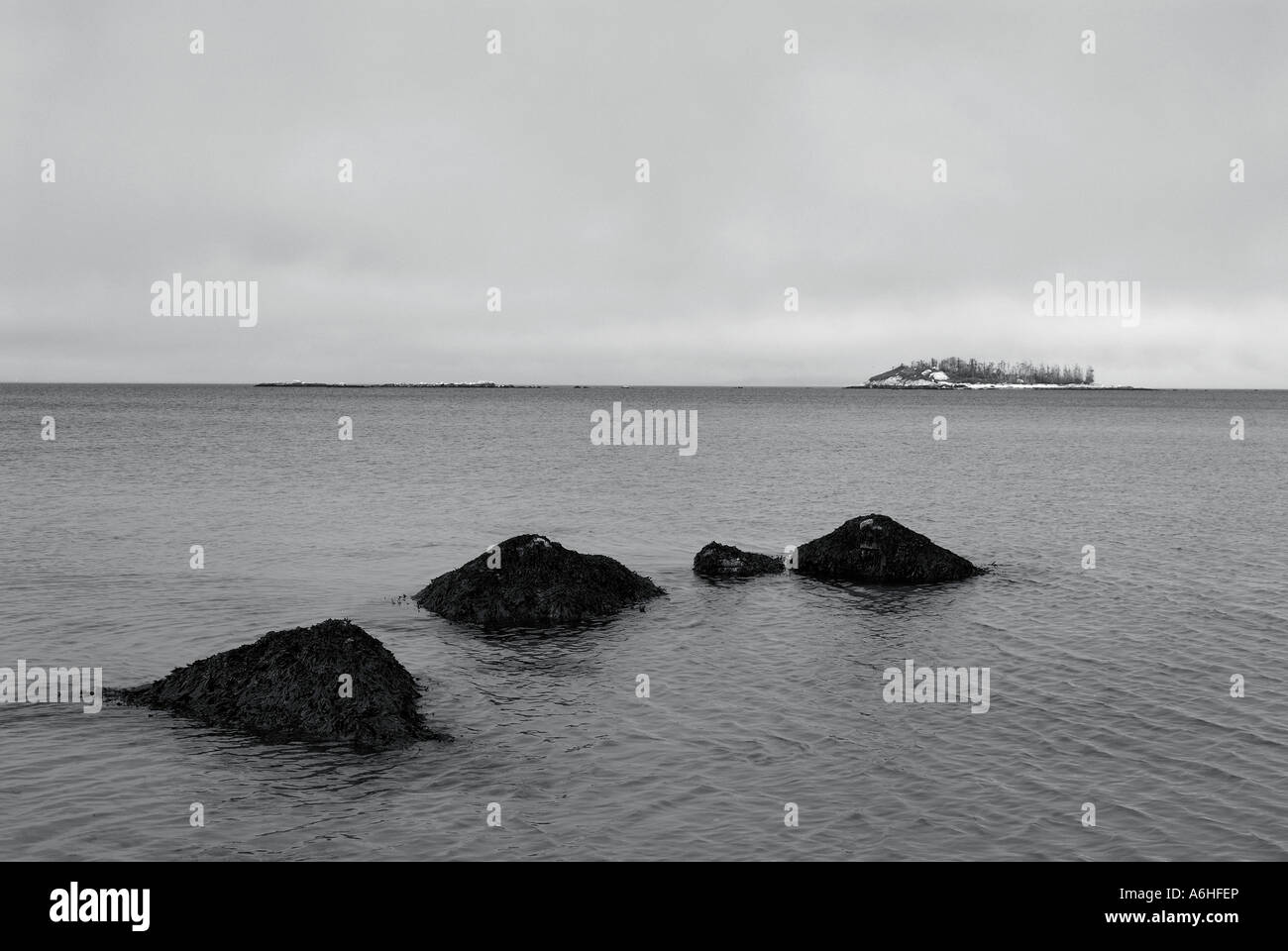 Four rocks emerging from water Stock Photo - Alamy