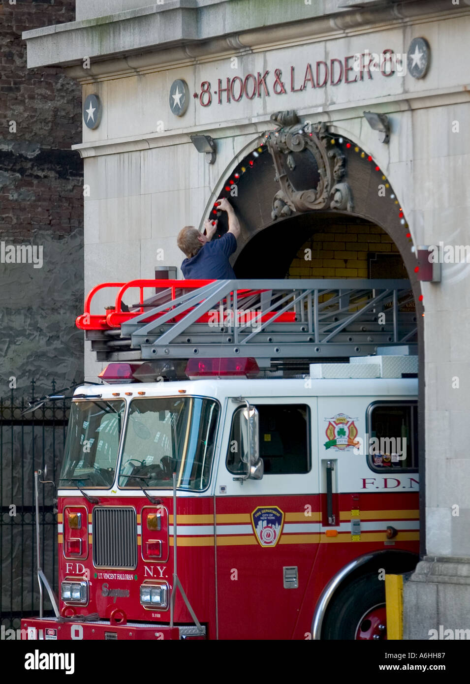 Fireman decorating a firehouse for Christmas Stock Photo - Alamy