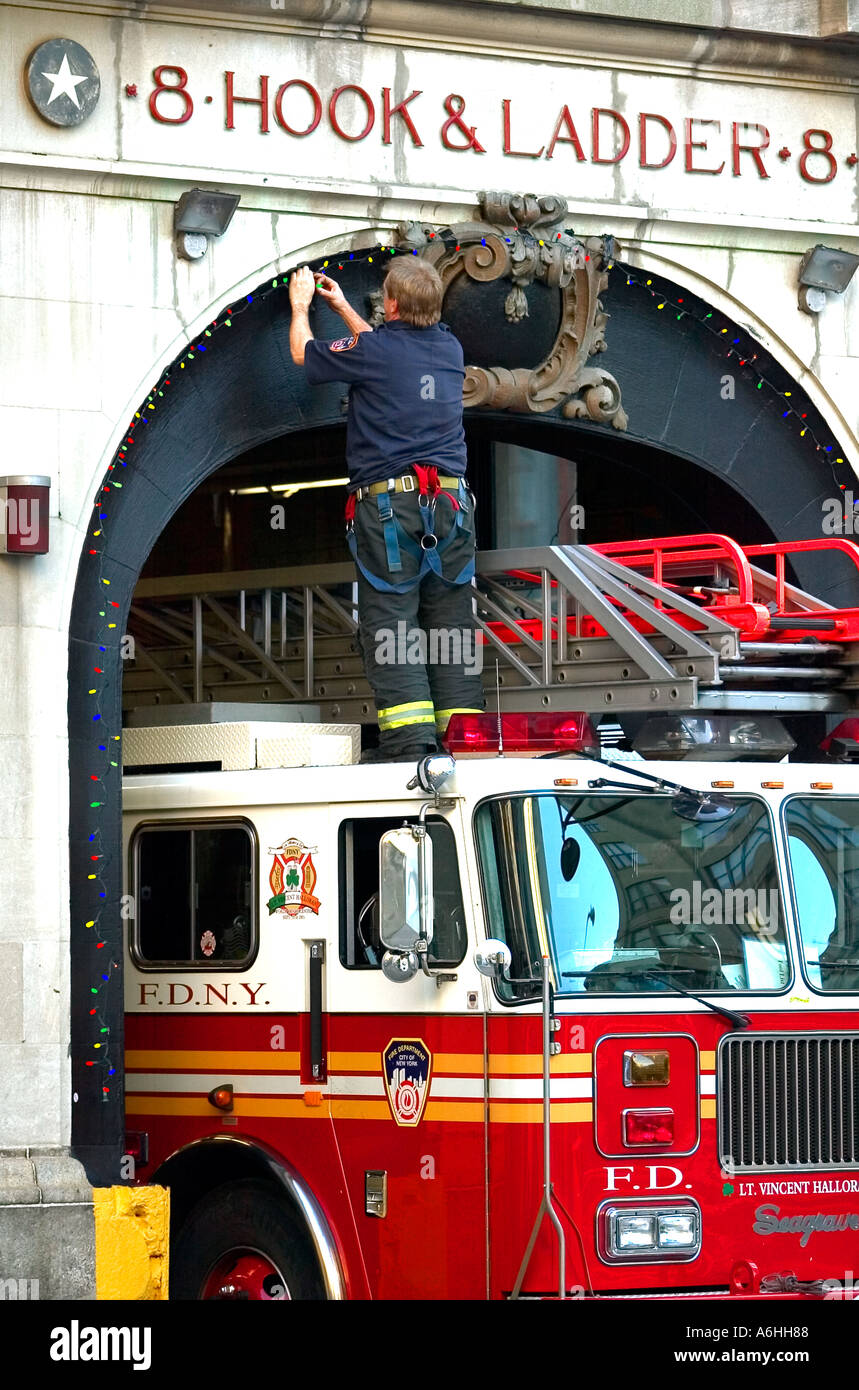 Fireman decorating a firehouse for Christmas Stock Photo - Alamy