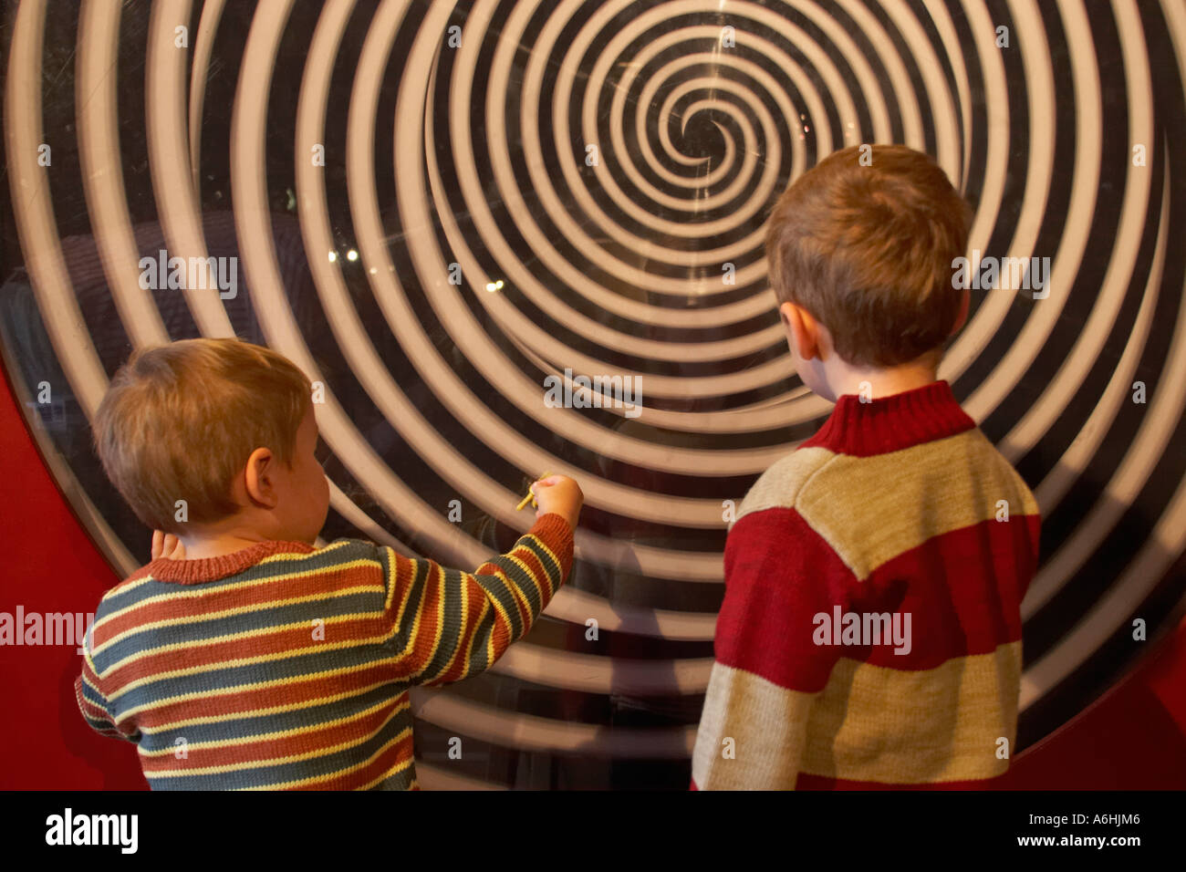 Two young boys children experimenting and playing with a spinning ...