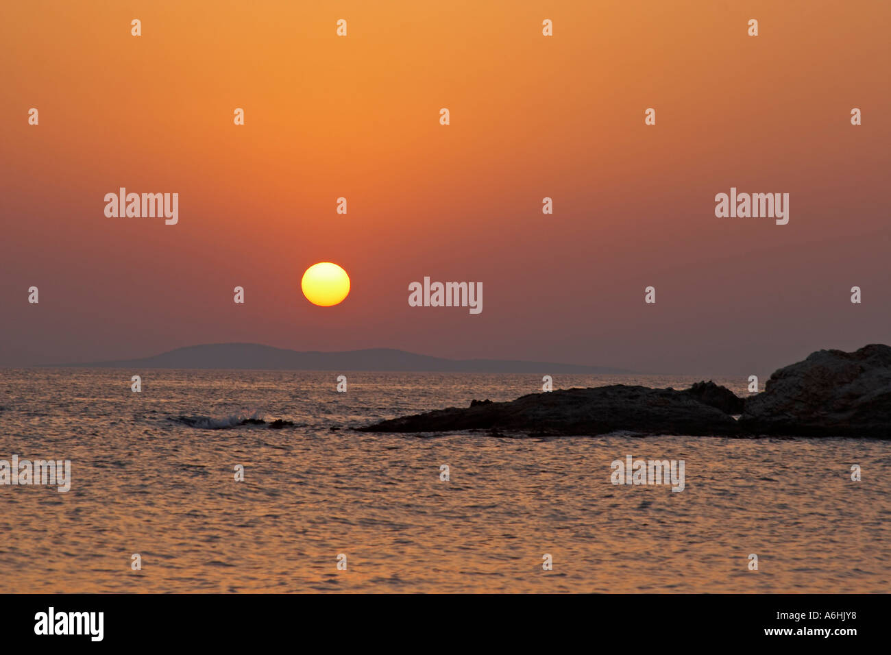 Sunset with sun setting into the sea at Mavro Lithari in Attiki or ...