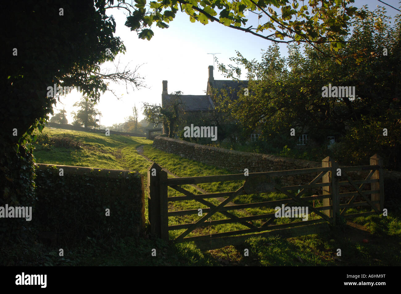 A country farm gate and farmhouse in the Cotswolds, England Stock Photo ...
