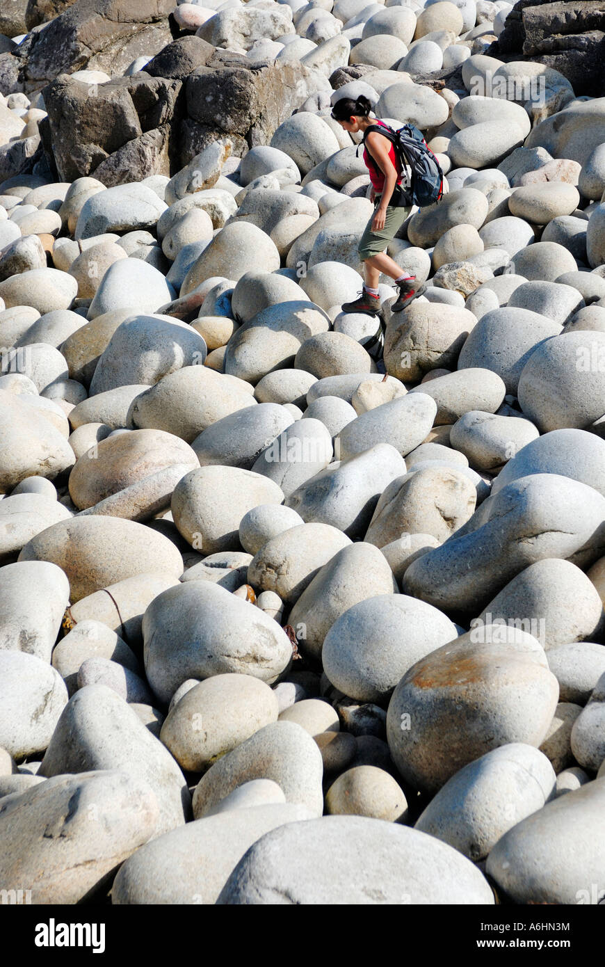 Woman walking on Pebble beach in Cornwall, England, United Kingdom ...