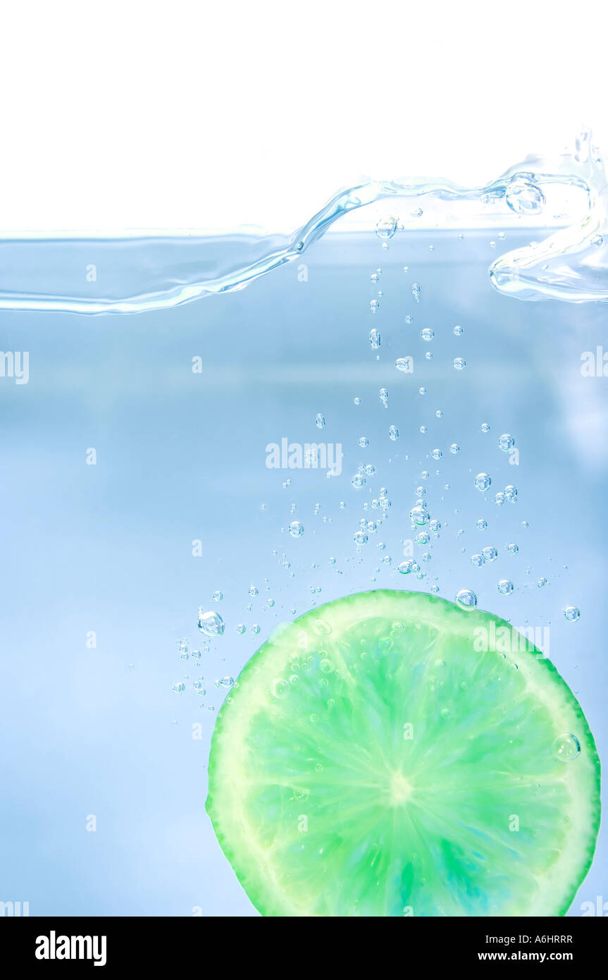Lime dropped into water Stock Photo - Alamy