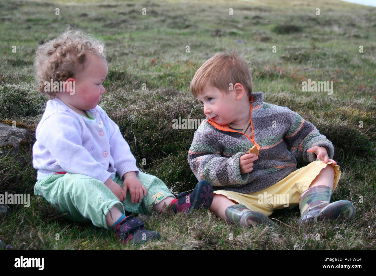 two children young boy looking at baby girl outdoors with exasperated ...