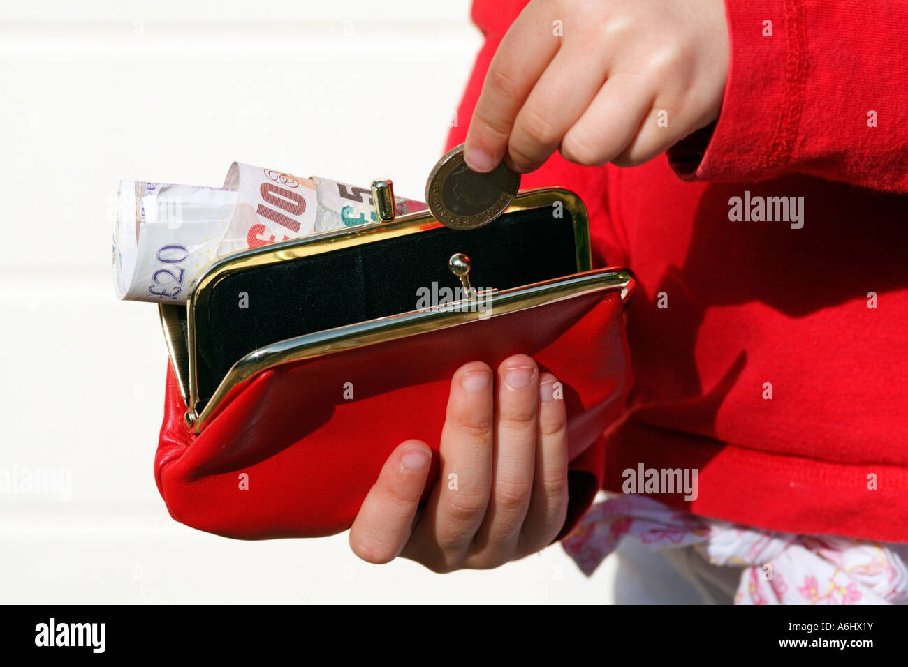 Child holding a red purse with pocket money Cash in the hand Stock ...