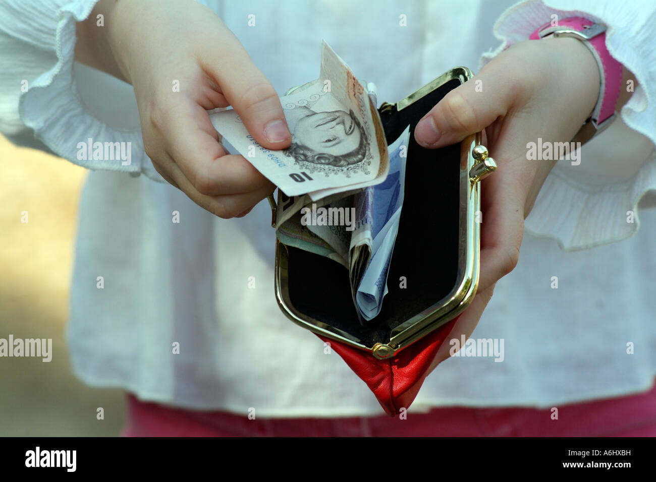 Child holding purse with pocketmoney Cash in the hand Stock Photo - Alamy