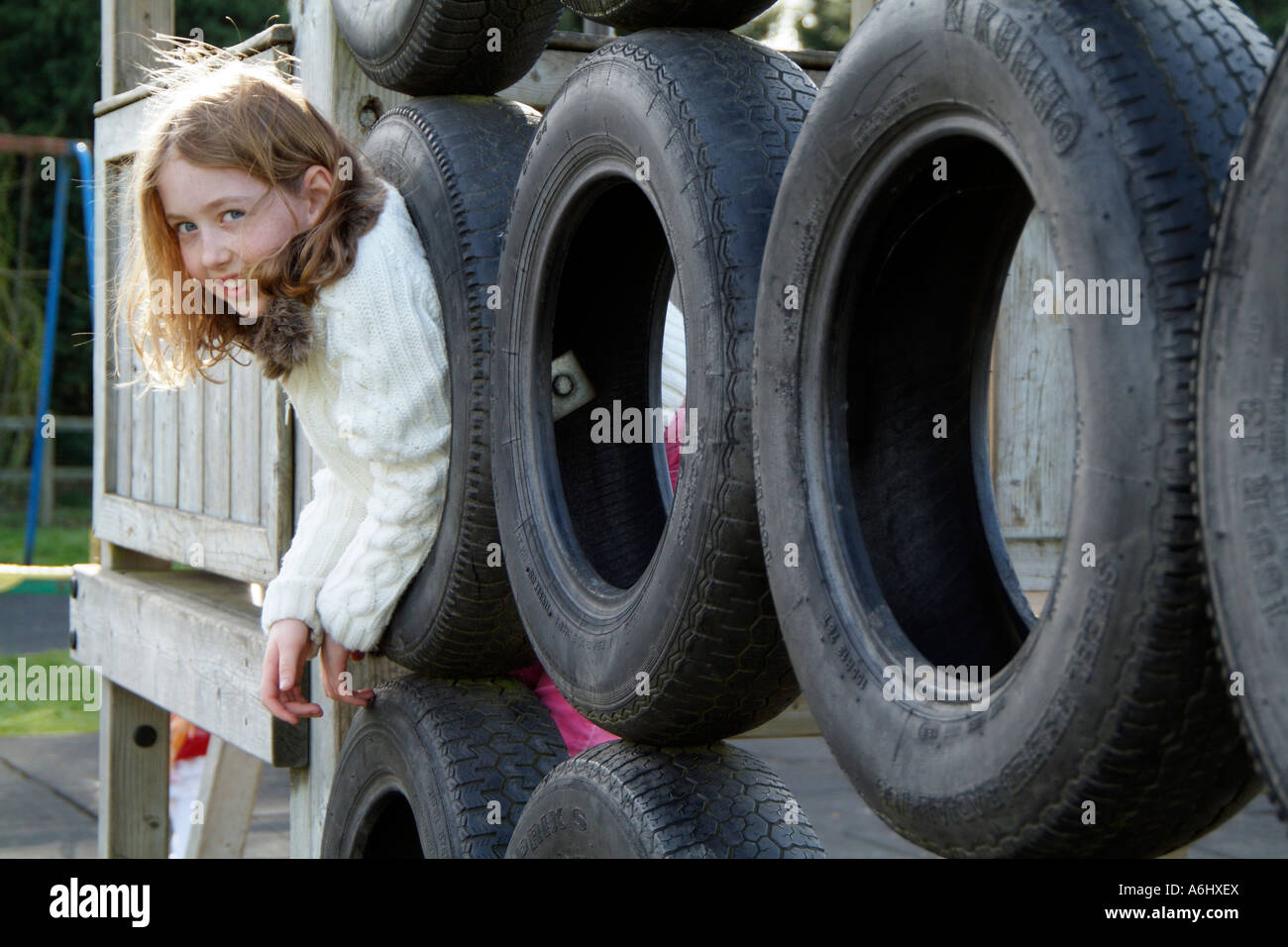 Girl playing on old car tyres Childrens playground Recycling Recyled ...