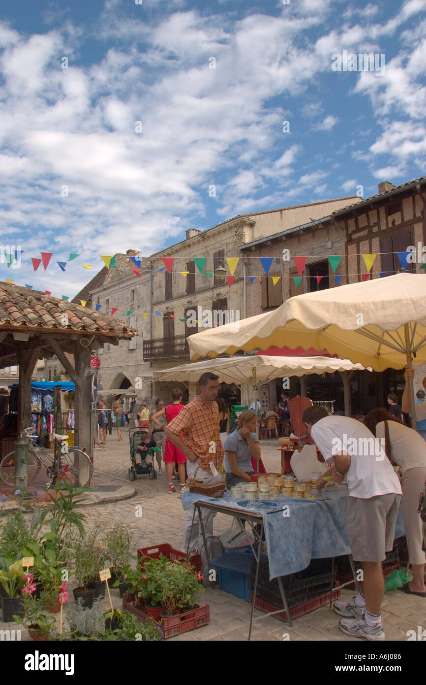 Shoppers looking at local produce on market stall in French medieval ...