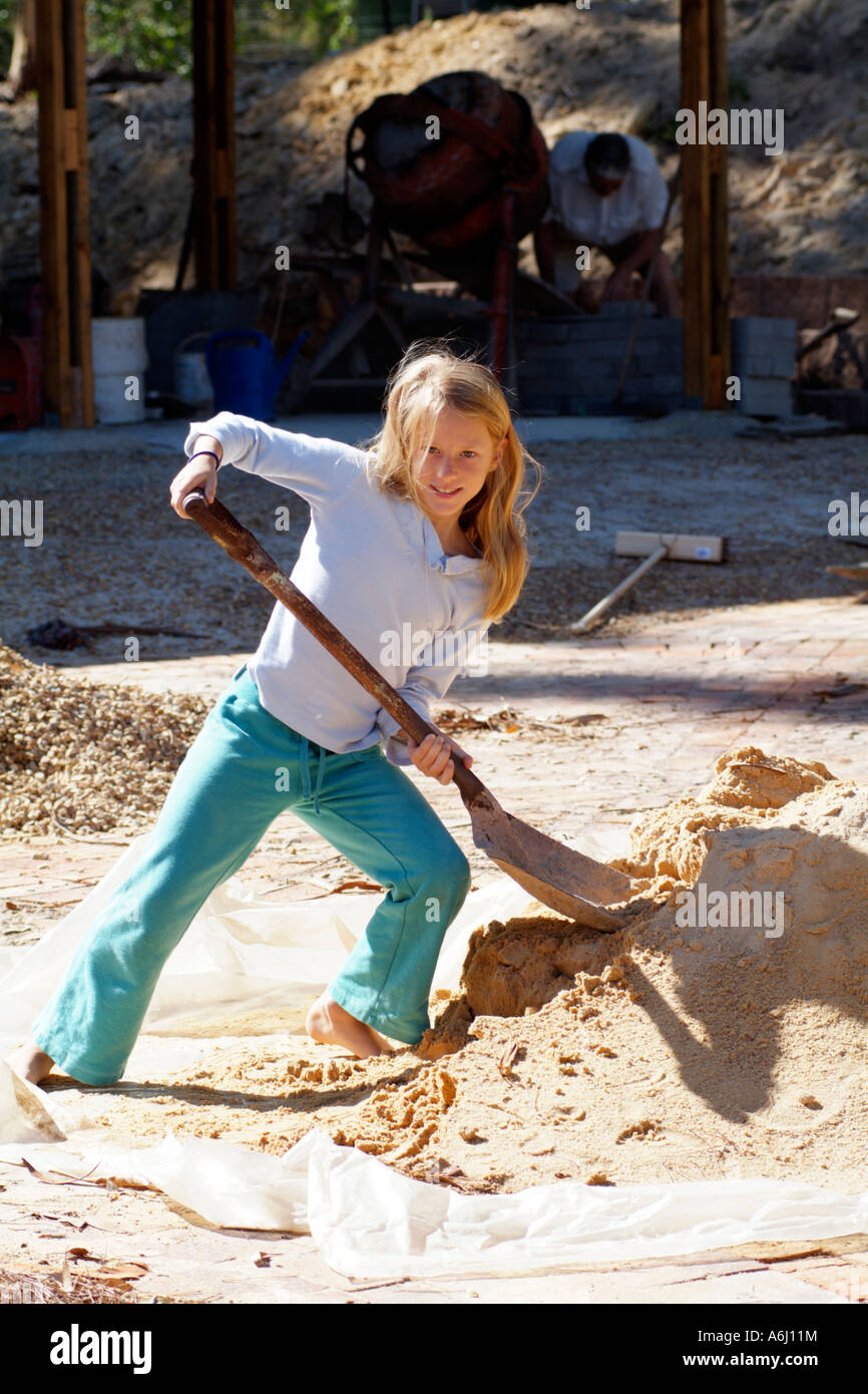 Little girl with a spade digging in a pile of sand Stock Photo - Alamy