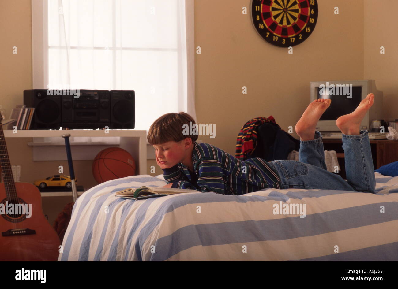 Boy on Bed in Room Stock Photo - Alamy
