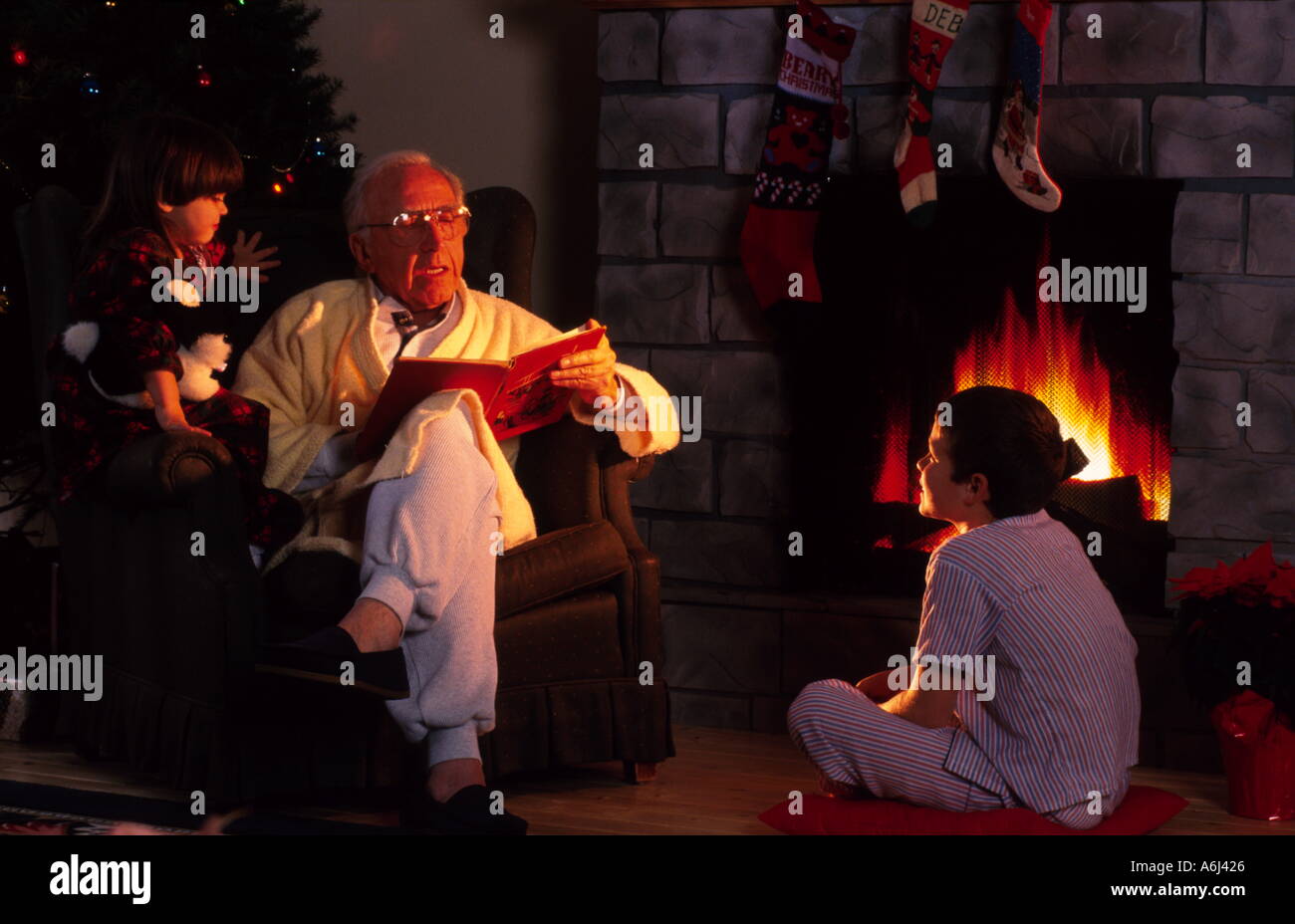 Grandfather Reading to Grandchildren Stock Photo - Alamy