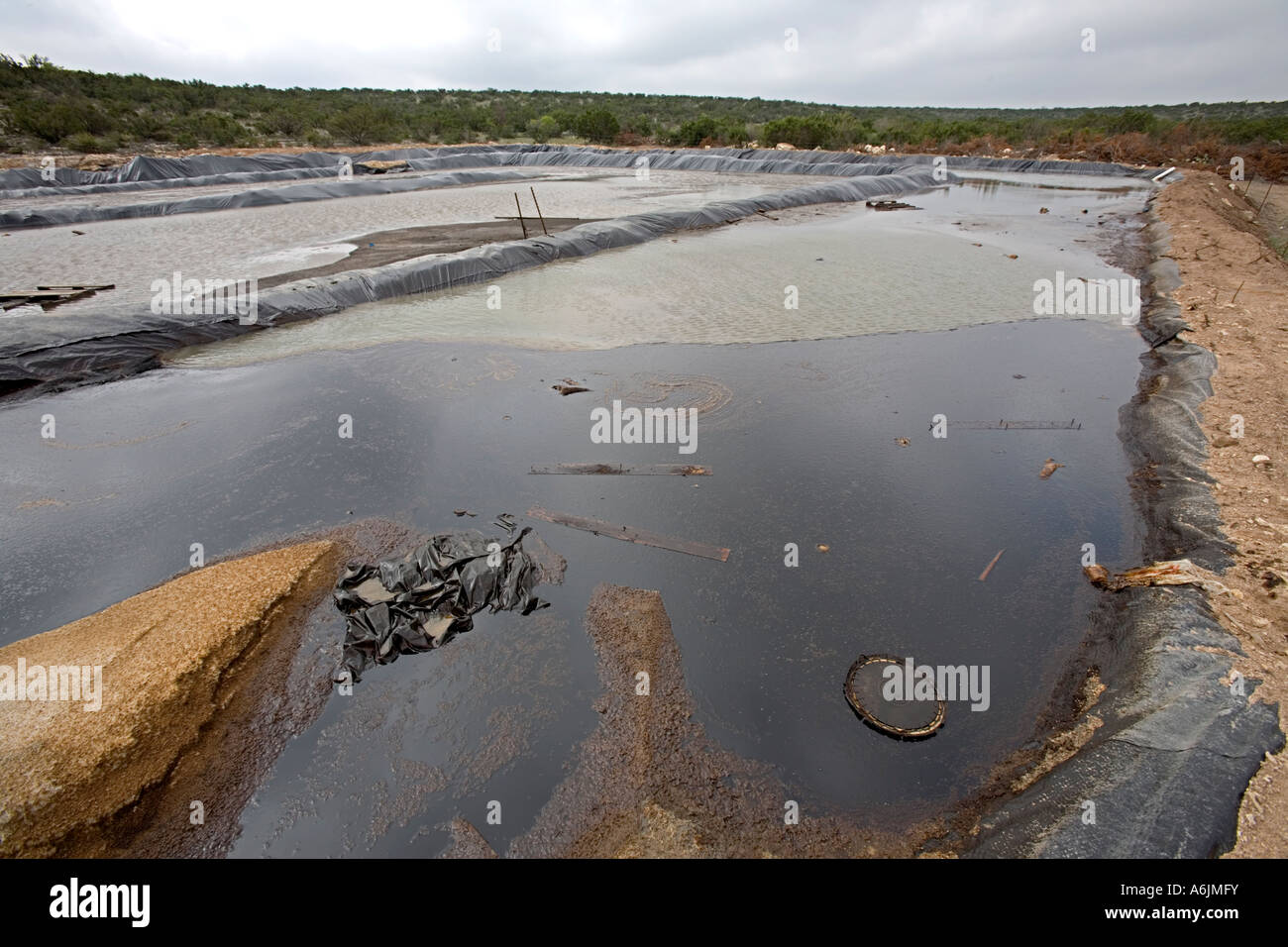 Crude oil in holding pits on an oil field in West Texas waste from a ...