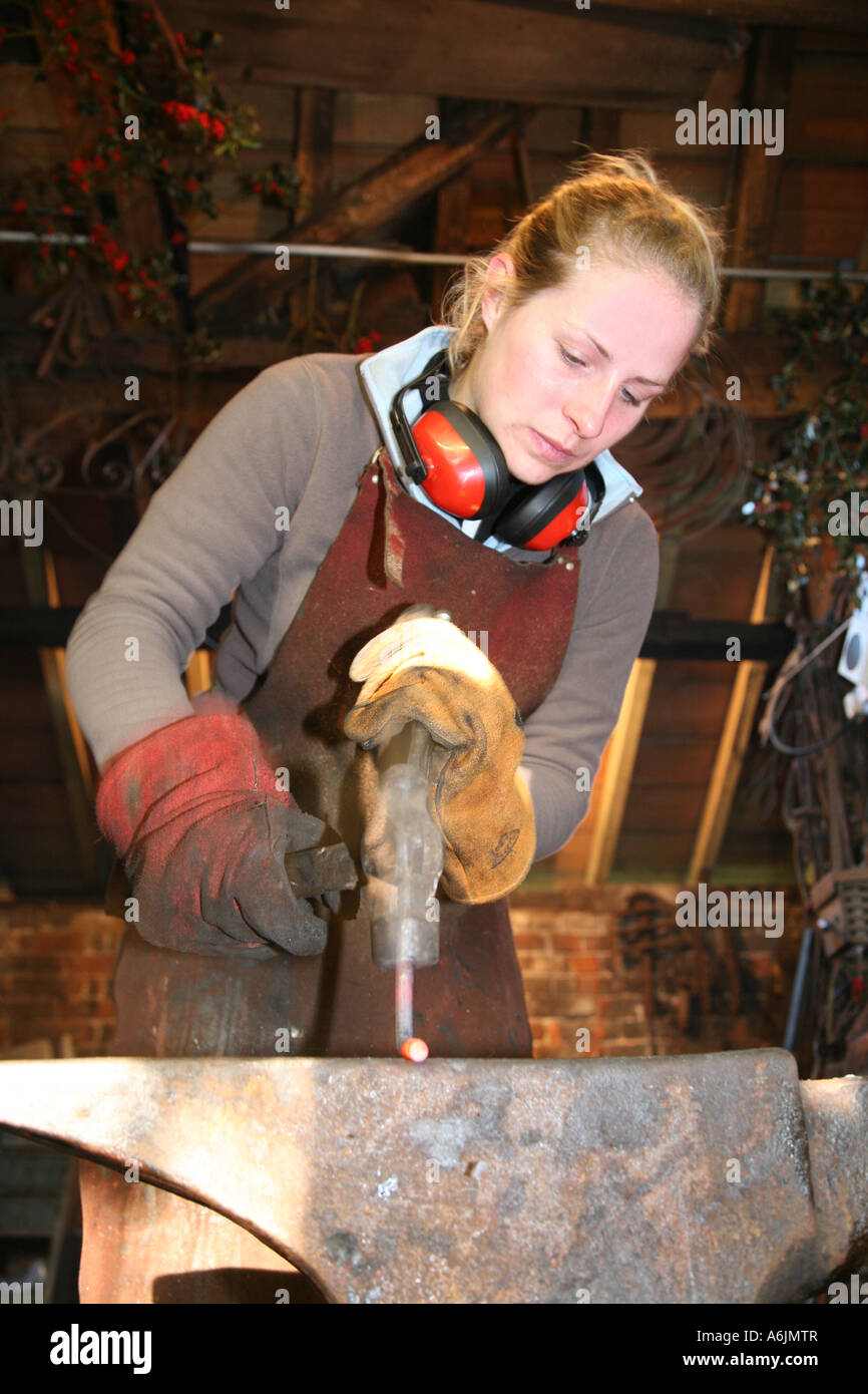 A female blacksmith working on some iron in her forge Stock Photo - Alamy