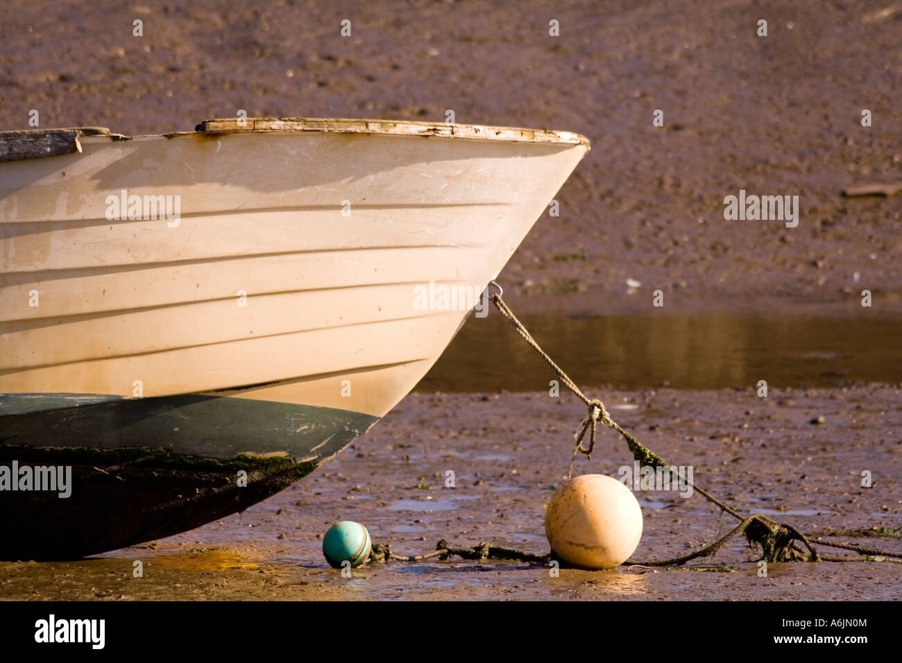 Boat and floats sitting in the mud Stock Photo - Alamy