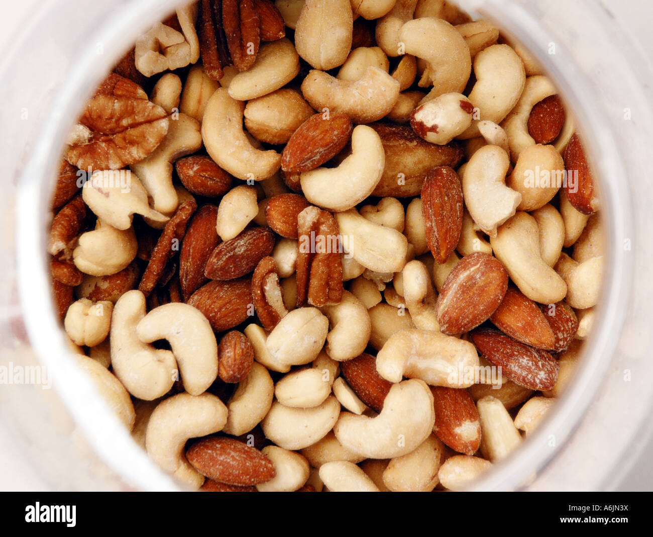 Assortment of nuts in a jar peanuts cashews walnuts pecans and almonds ...