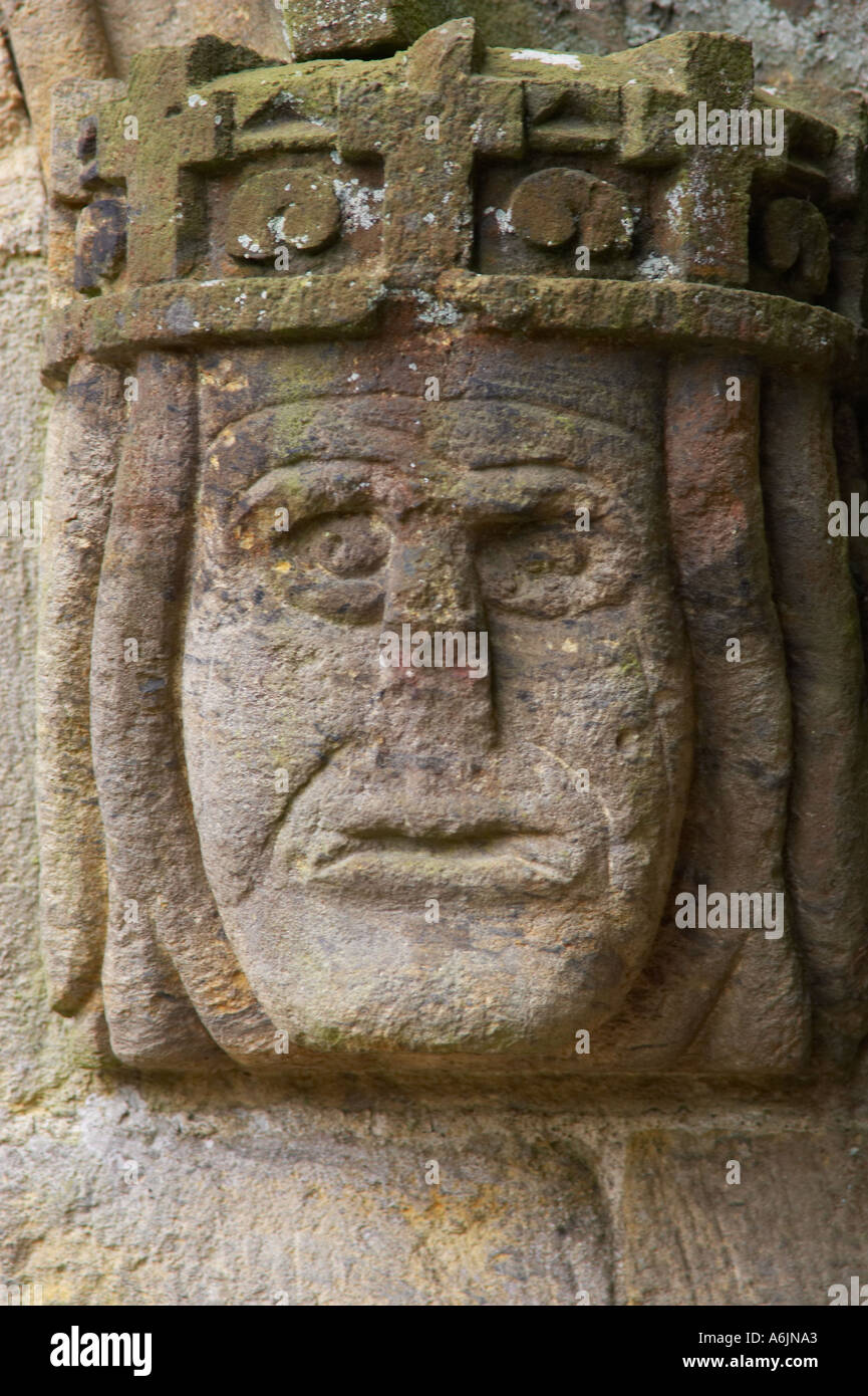 A carved stone face at side of entrance of Church of All Hallows at ...