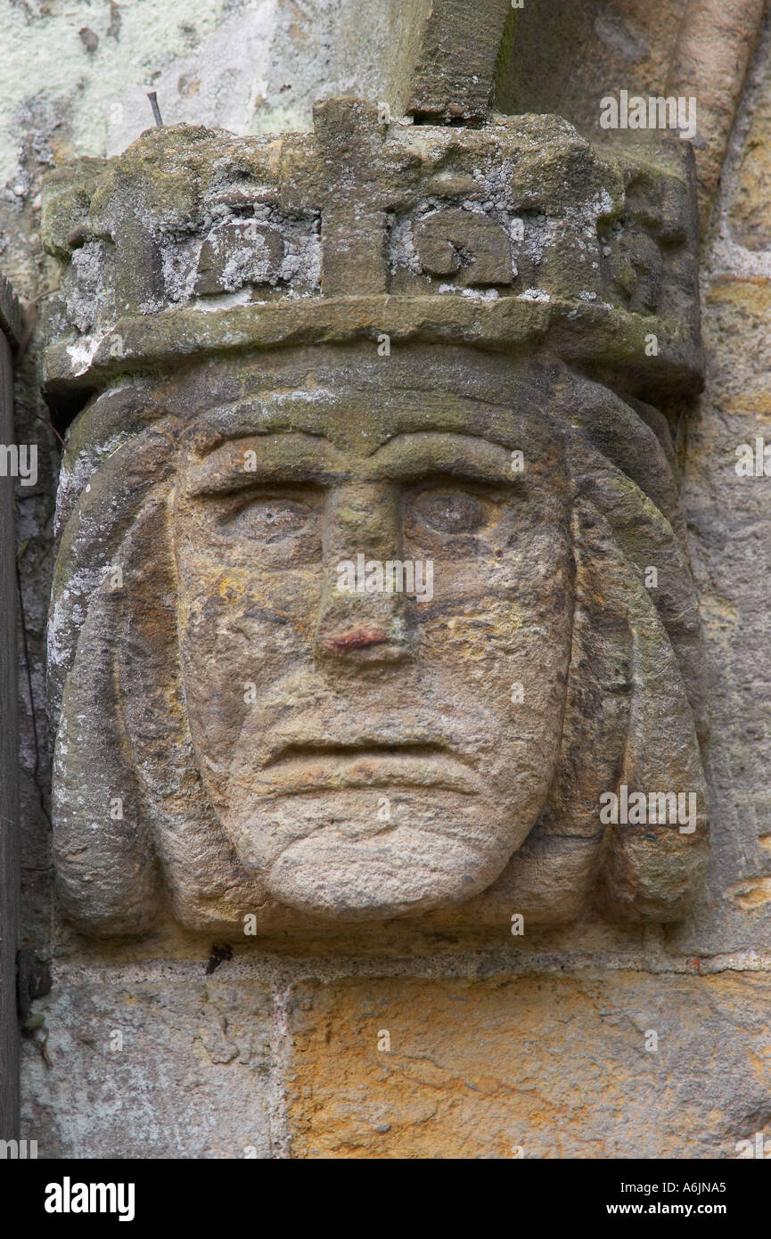 A carved stone face at side of entrance of Church of All Hallows at ...
