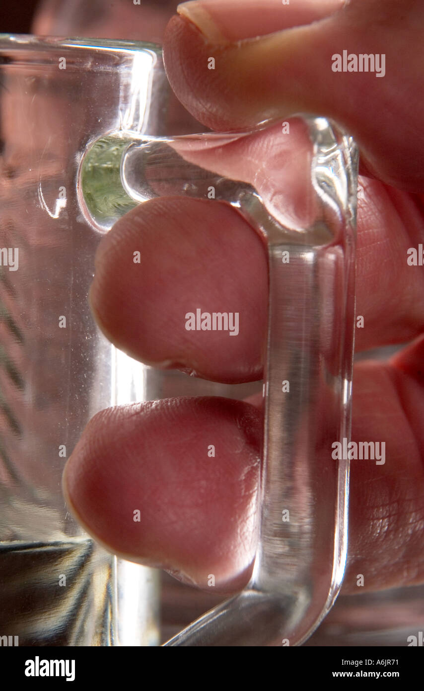 Male fingers holding glass by handle Stock Photo - Alamy