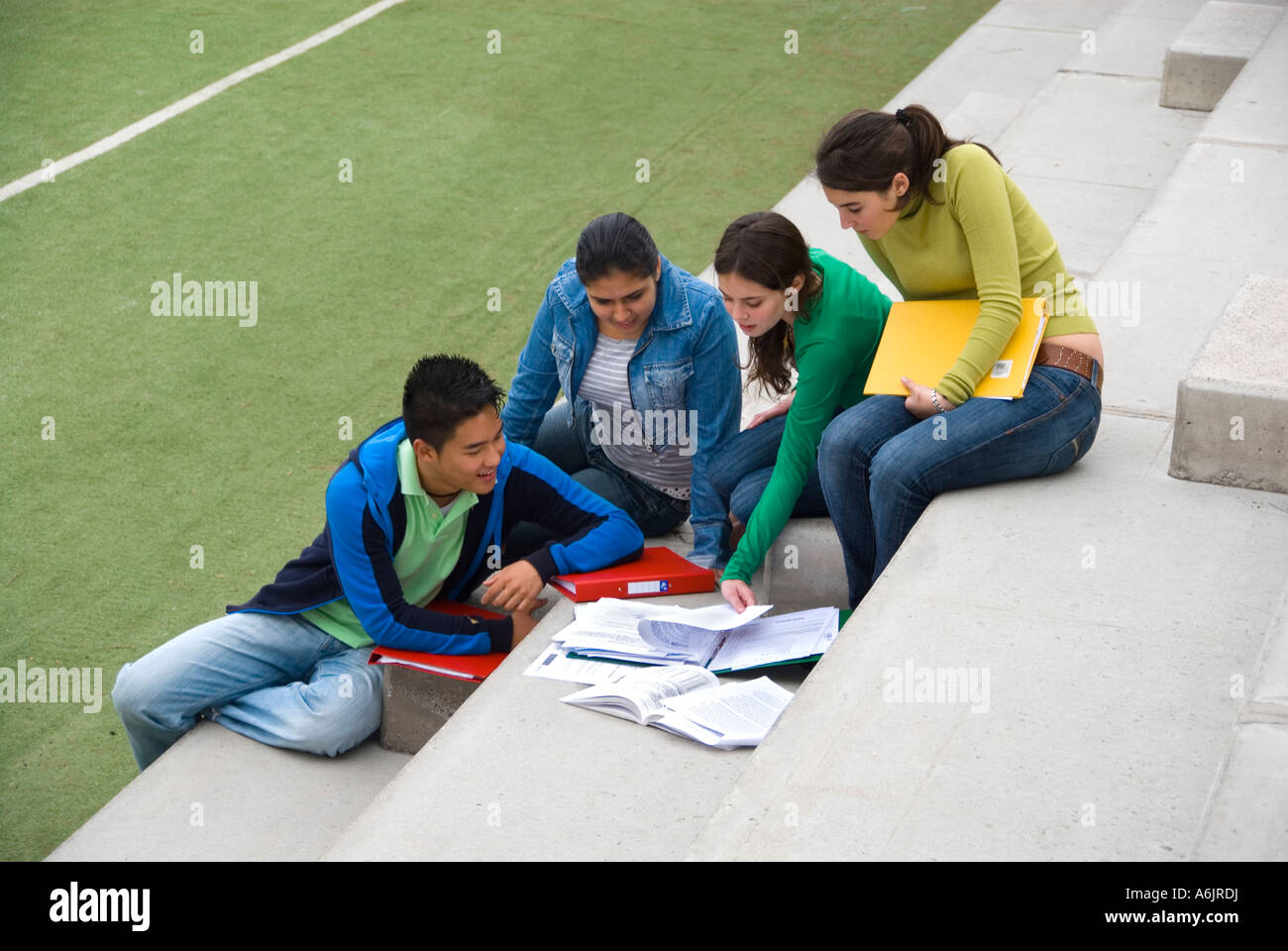 Multiracial group of four teenage senior students sitting relaxing and ...