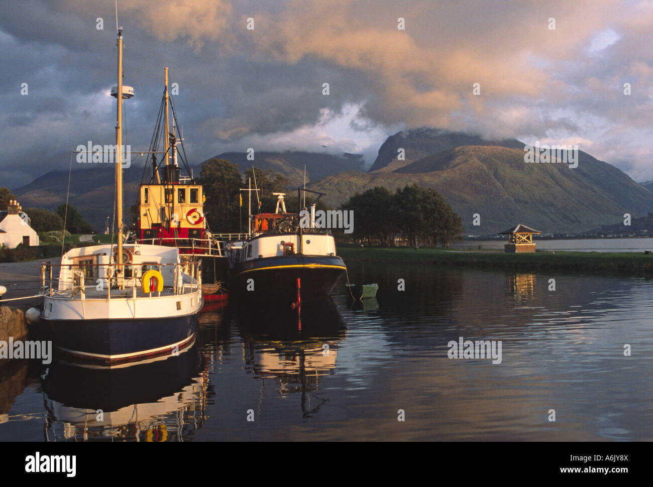 Vessels tied up in Corpach Basin in evening light with Ben Nevis behind ...