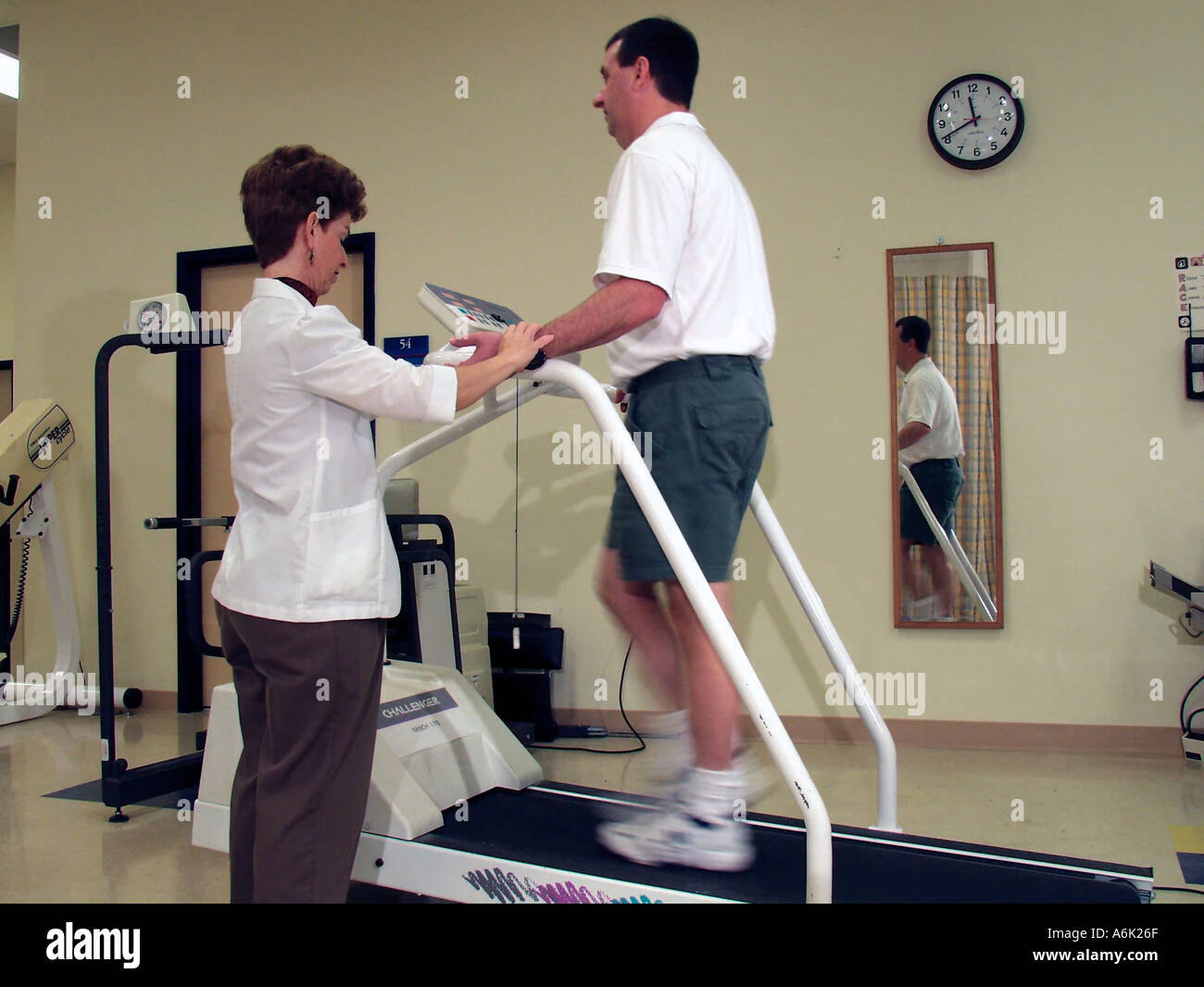 Man running on a treadmill with a therapist checking his pulse Stock ...