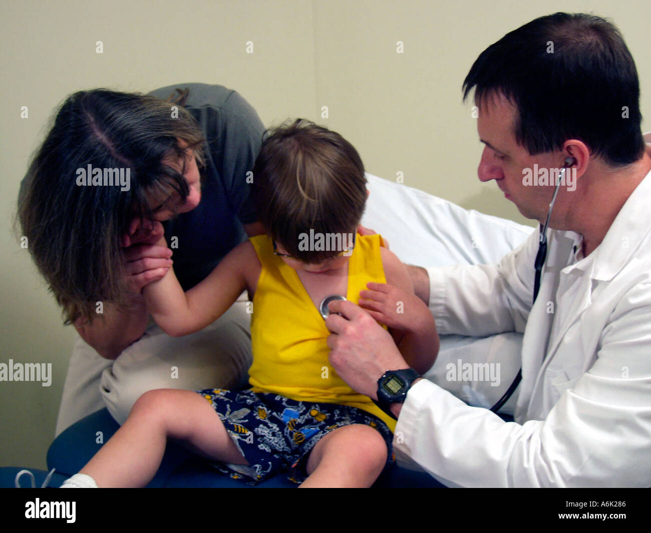 Young boy carefully watching stethoscope during a medical examination ...