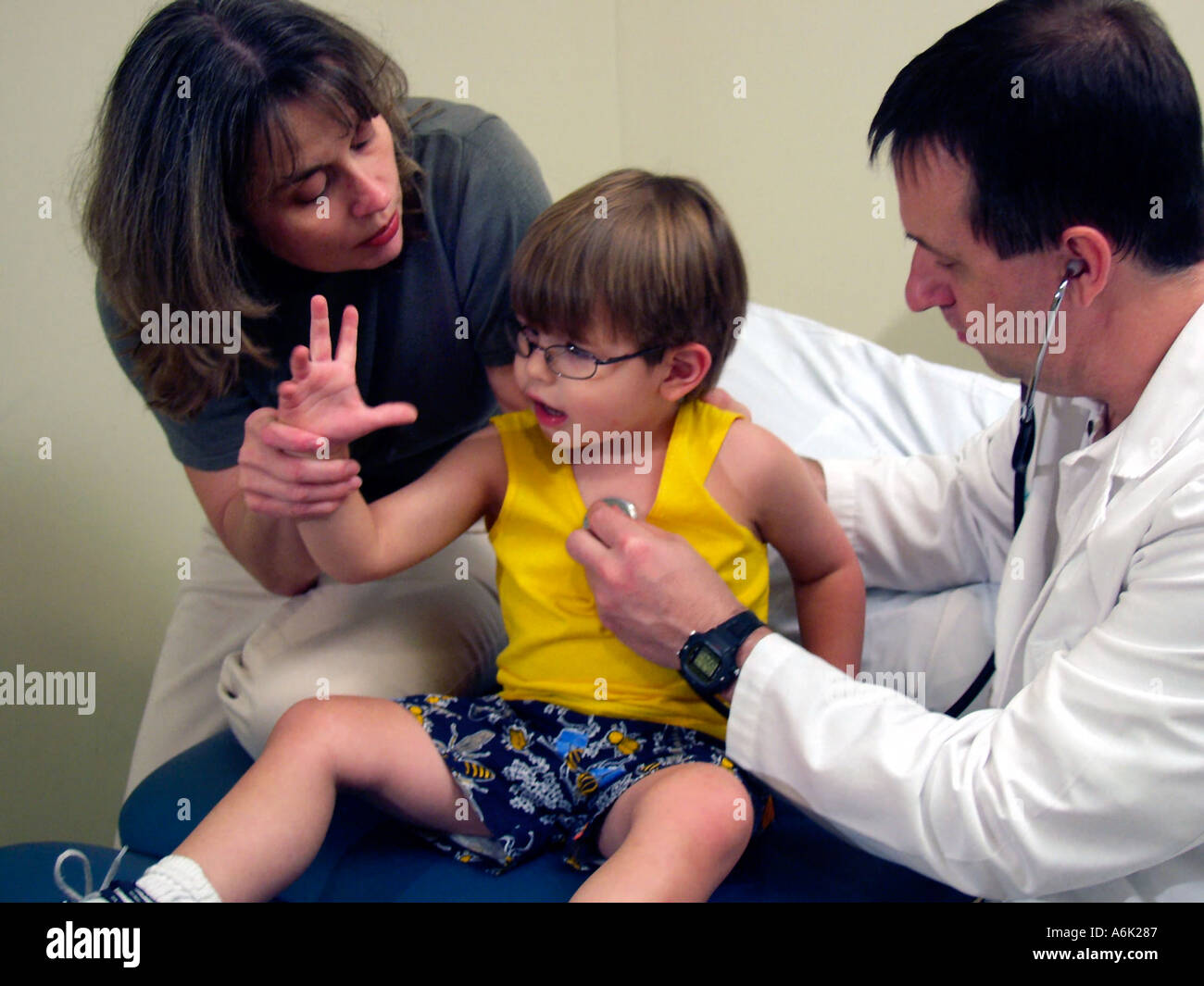 Young boy undergoing a medical examination with his mother or nurse by ...