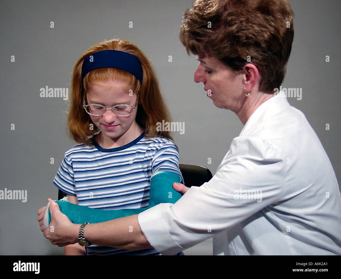 Young girl with a cast on her arm receiving physical therapy shot ...