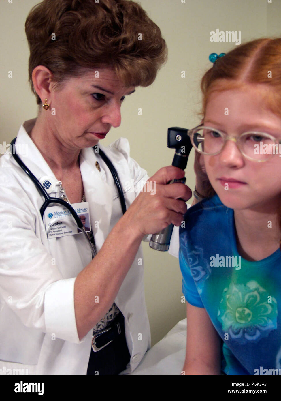 Young girl having her ear examined with an otoscope by a nurse Stock ...