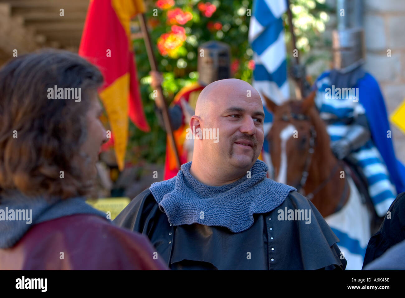 Man in medieval leather costume with soft focus medieval knights on ...