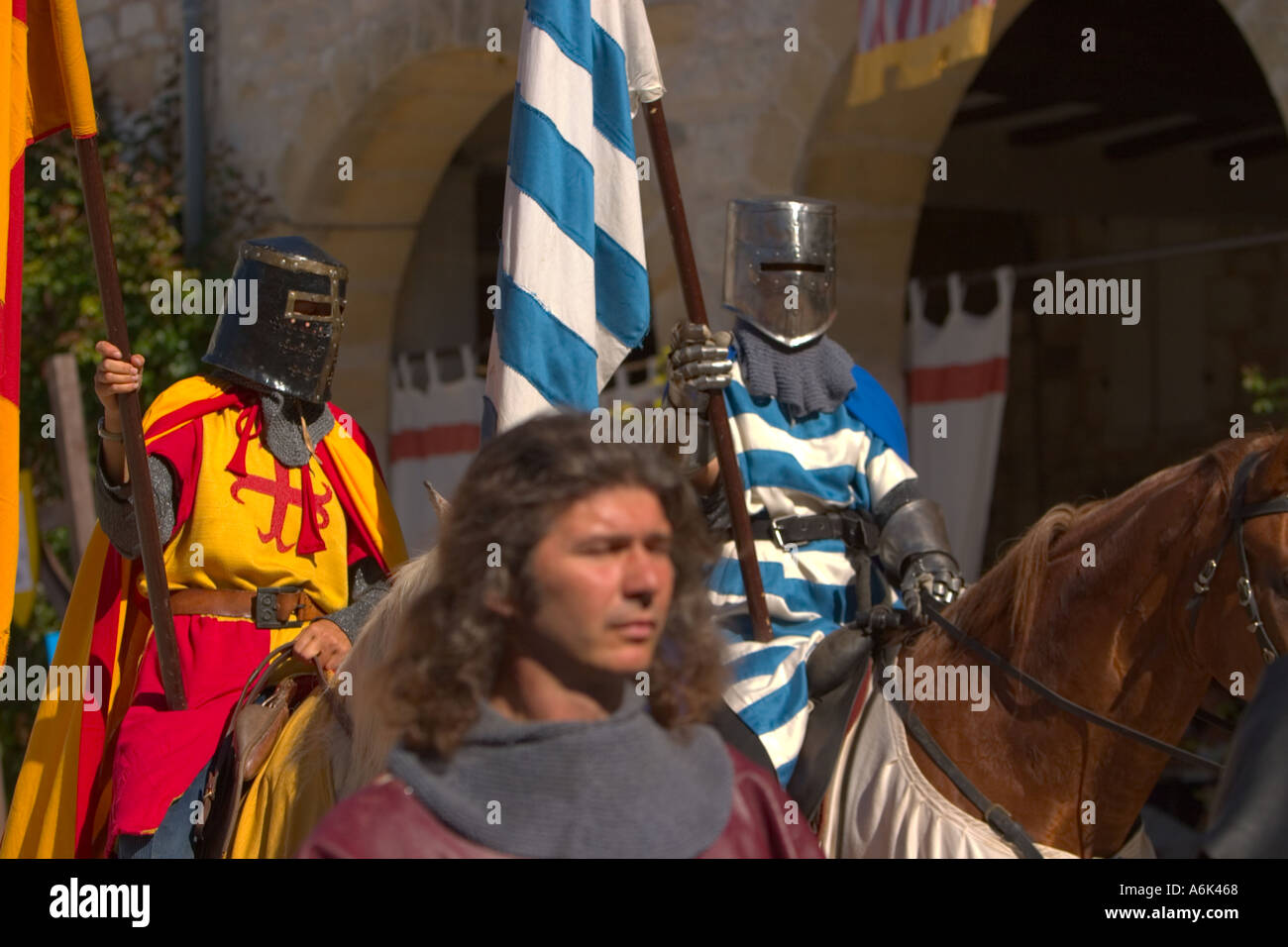 Two french medieval knights on horseback in background carrying banners ...