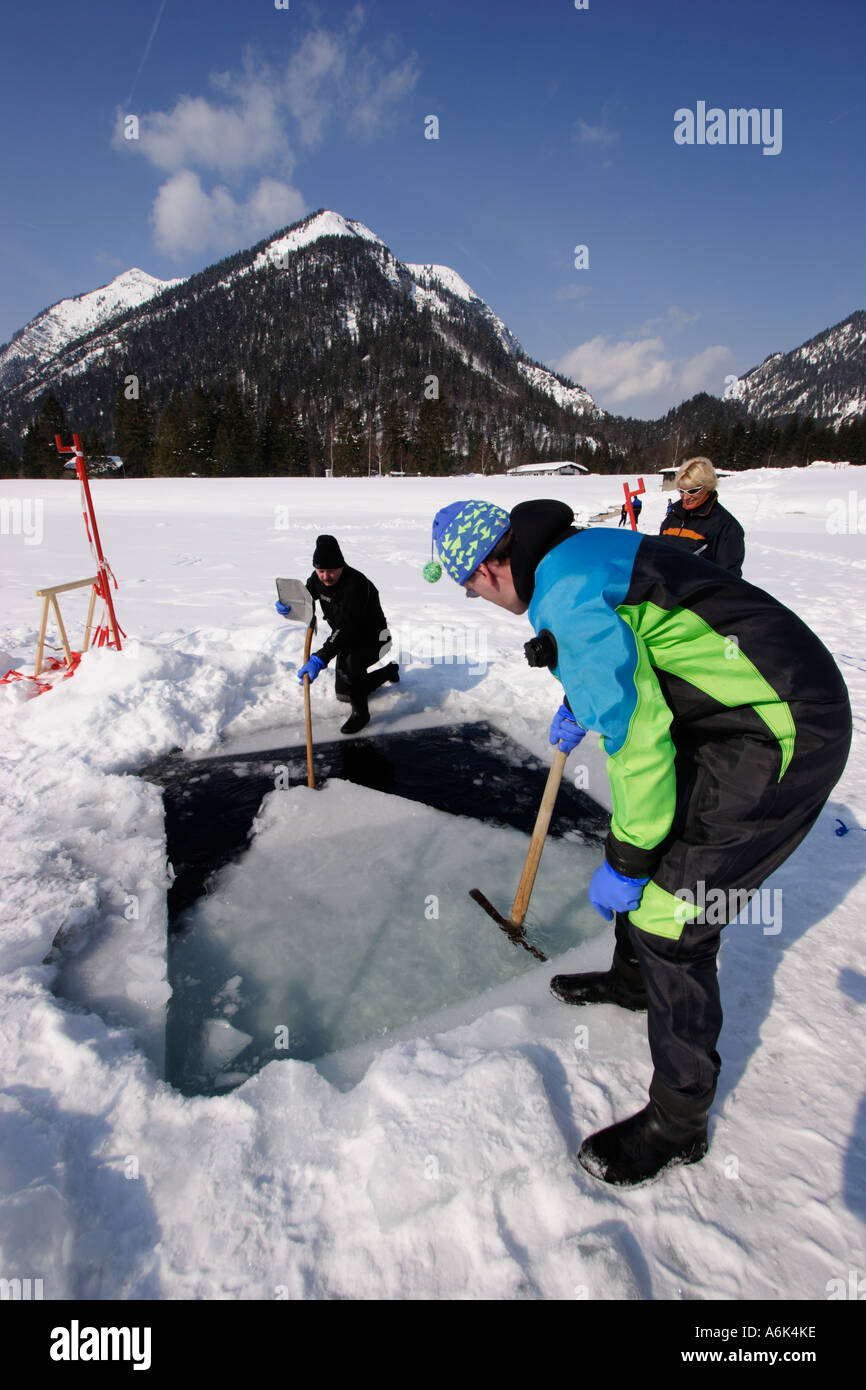 scuba diver opening ice hole on frozen lake Stock Photo - Alamy