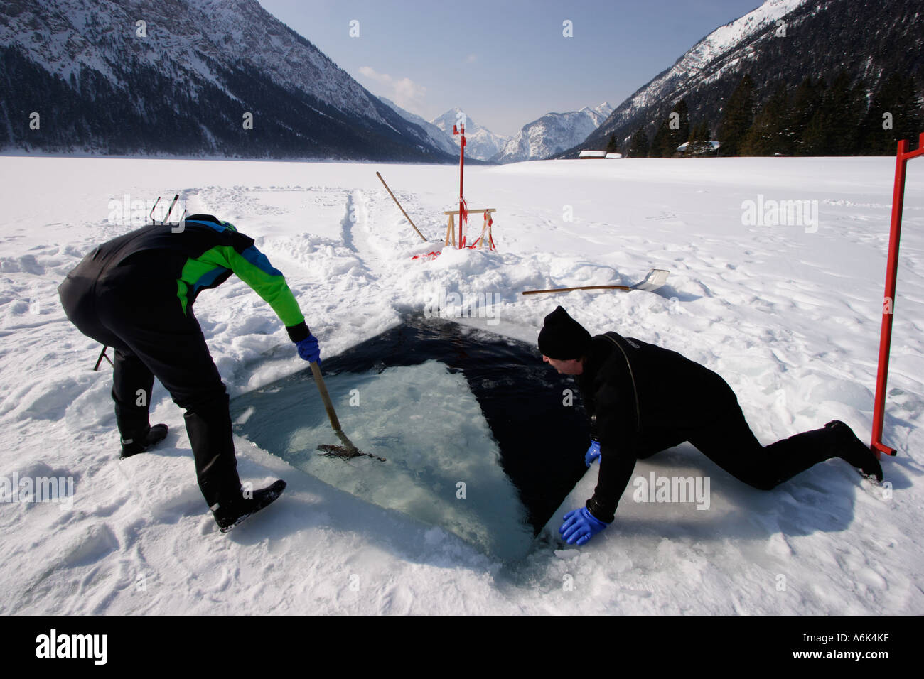 scuba diver opening ice hole on frozen lake Stock Photo - Alamy