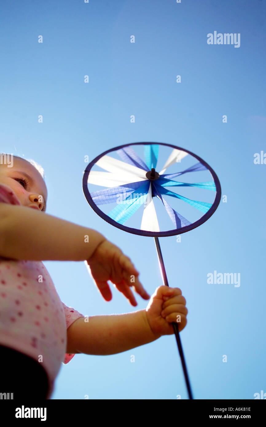 little baby holding a windwheel up in the sky Stock Photo - Alamy