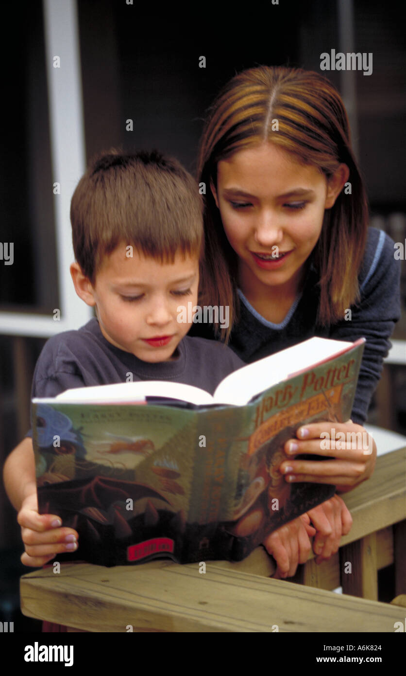 Big Sister reading to Little Brother Stock Photo - Alamy
