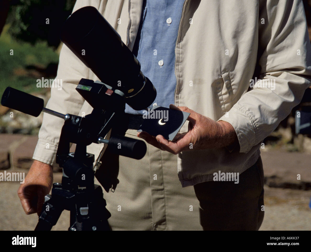 People watching solar eclipse through telescope lens with image ...