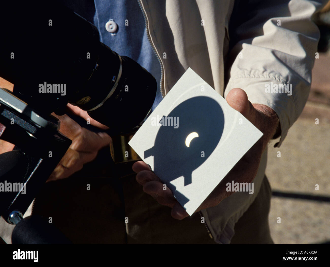 People watching solar eclipse through telescope lens with image ...