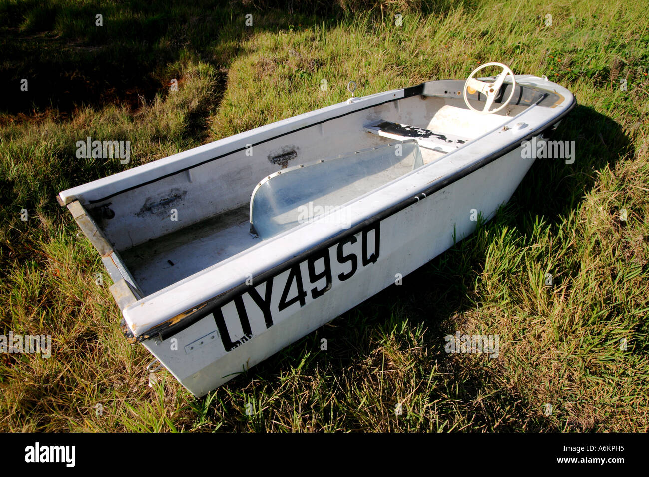 OLD DINGHY PULLED UP ON GRASS HORIZONTAL BAPDB5473 Stock Photo - Alamy