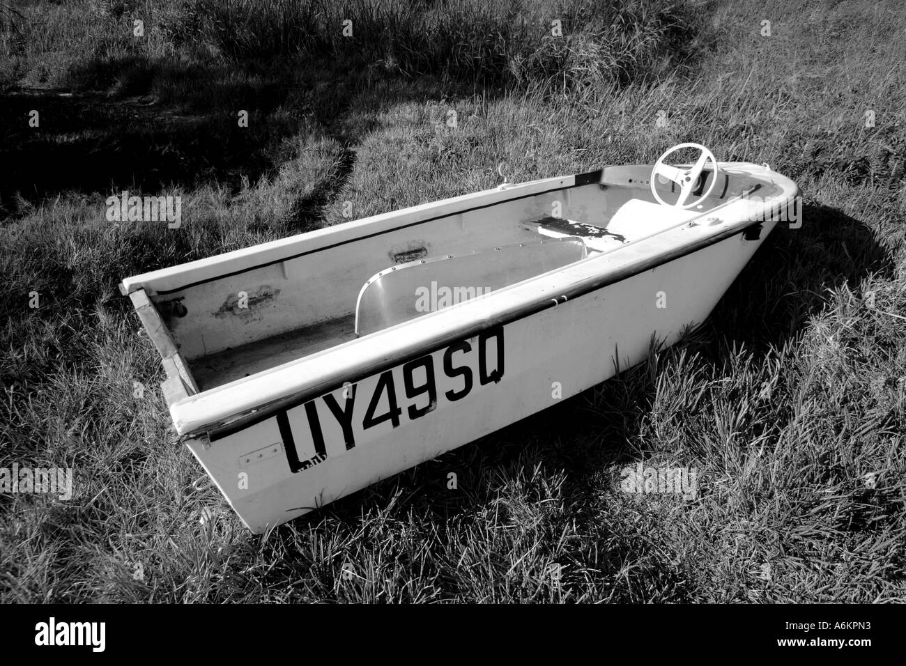 OLD DINGHY PULLED UP ON GRASS HORIZONTAL BAPDB5474 Stock Photo - Alamy