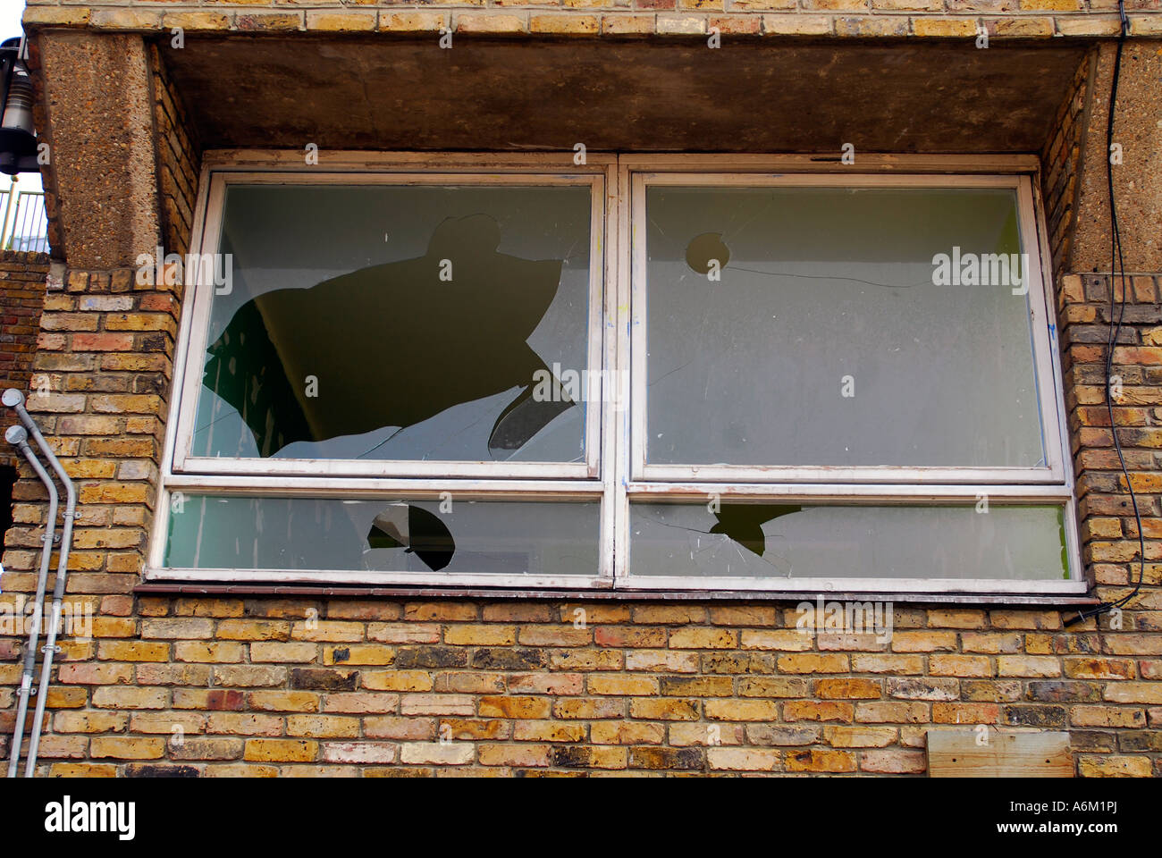 Broken windows on boarded up property on troubled housing estate in ...